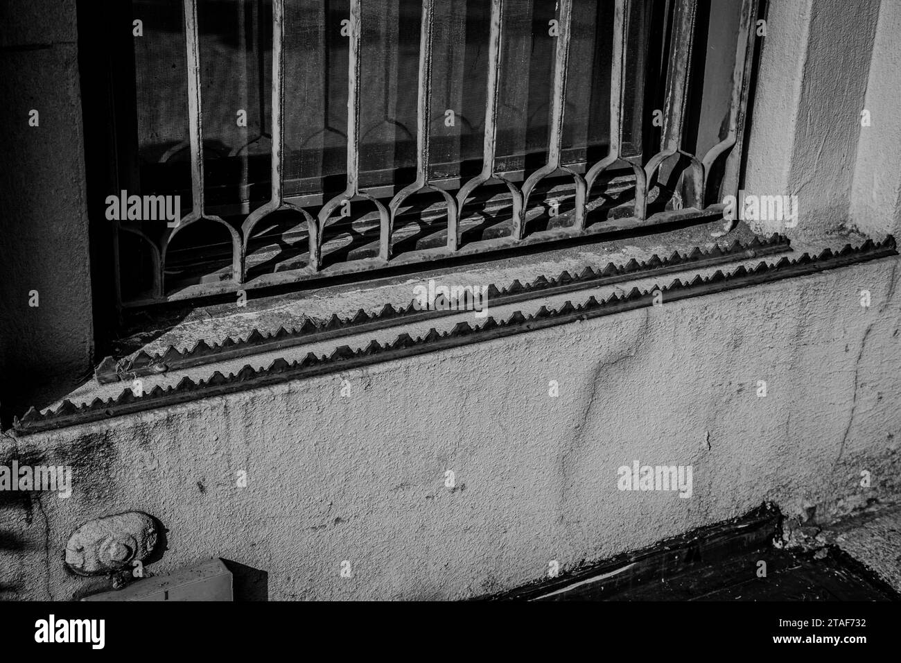 Spikes on a window stoop to keep people from sitting Stock Photo - Alamy