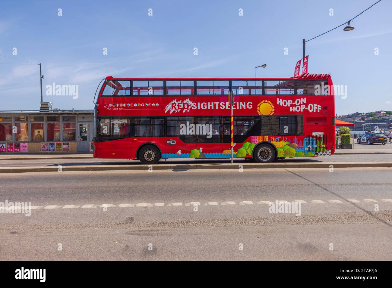 Close-up view of double-decker tourist bus traveling on road in streets ...