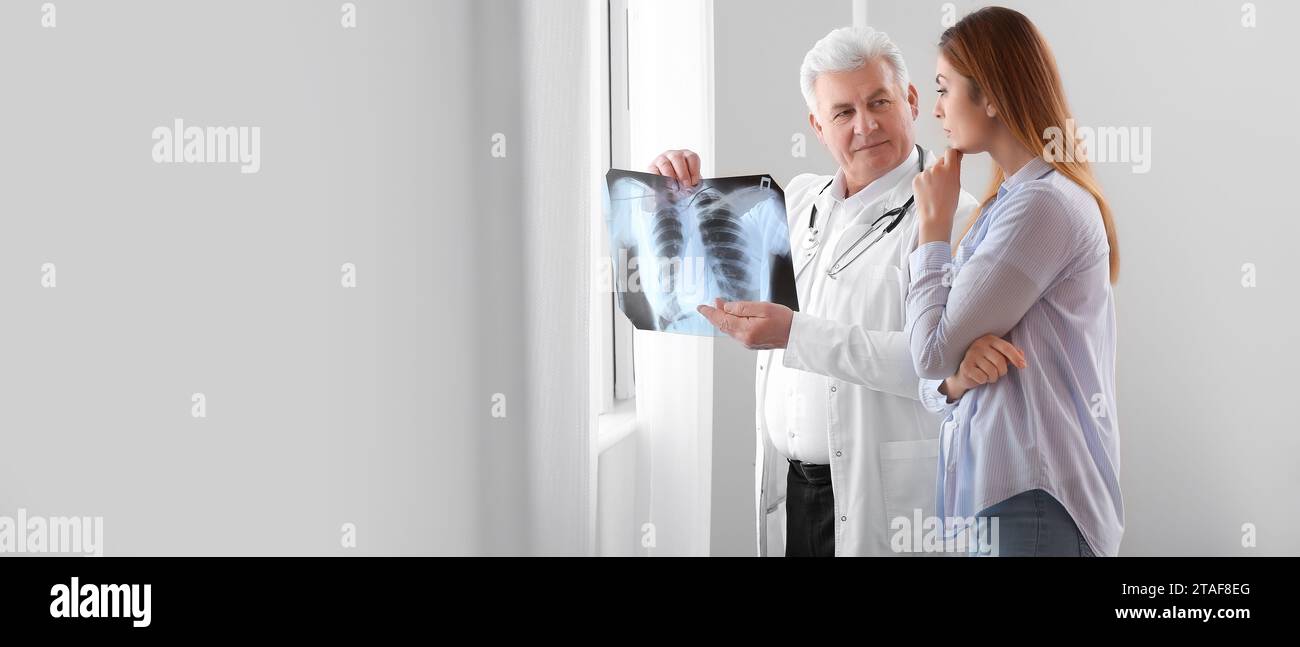 Senior doctor with x-ray image of lungs and female patient in clinic ...