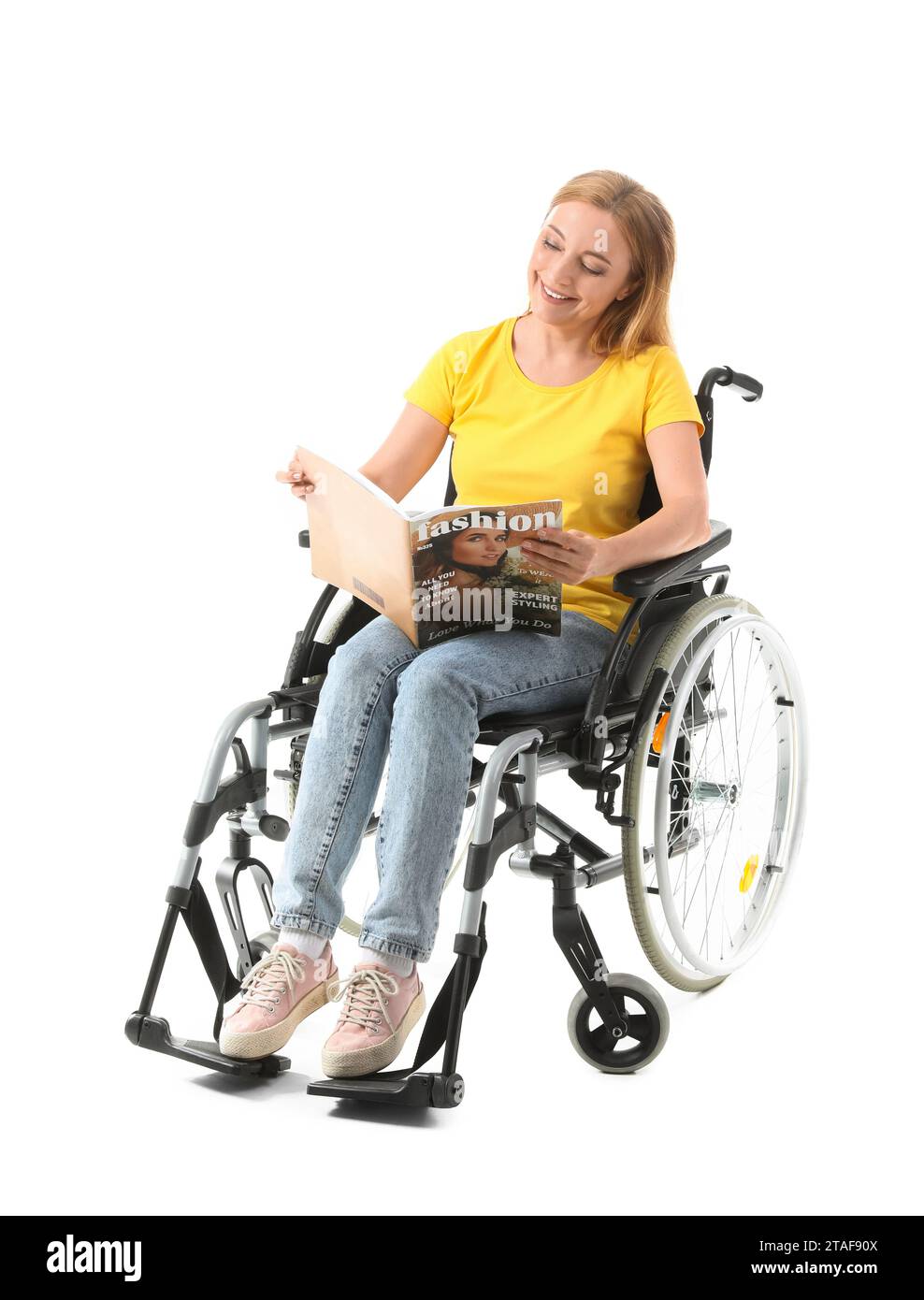 Mature woman in wheelchair reading magazine on white background Stock ...