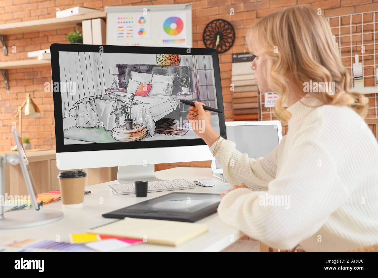 Female interior designer drawing at table in office Stock Photo - Alamy