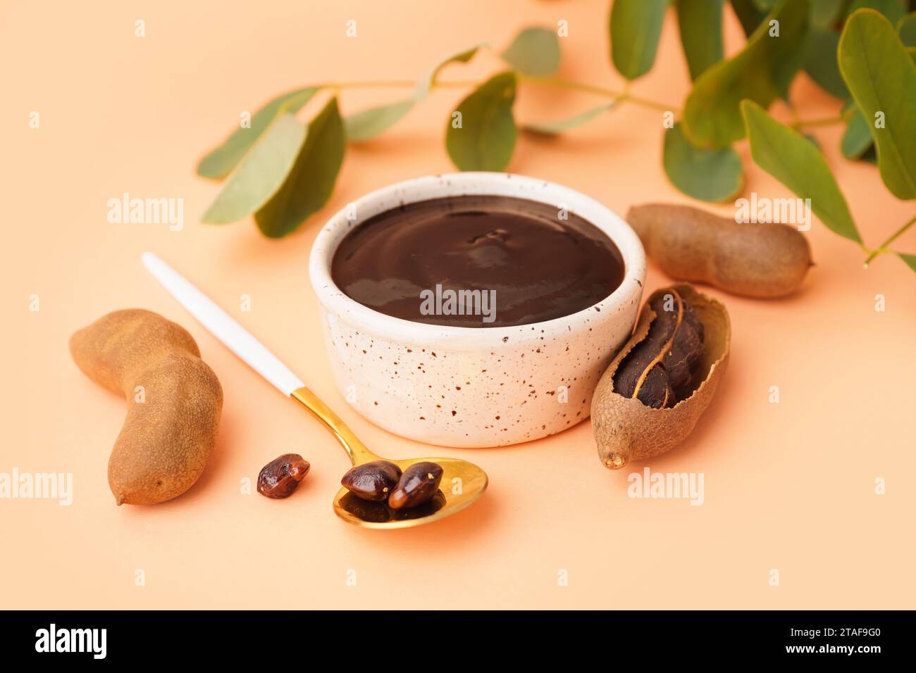Bowl with tasty tamarind jam and fruits on orange background Stock ...