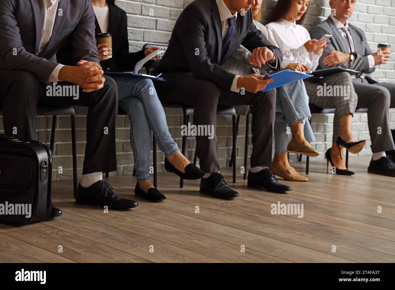 Business people waiting for their turn in office hall Stock Photo - Alamy