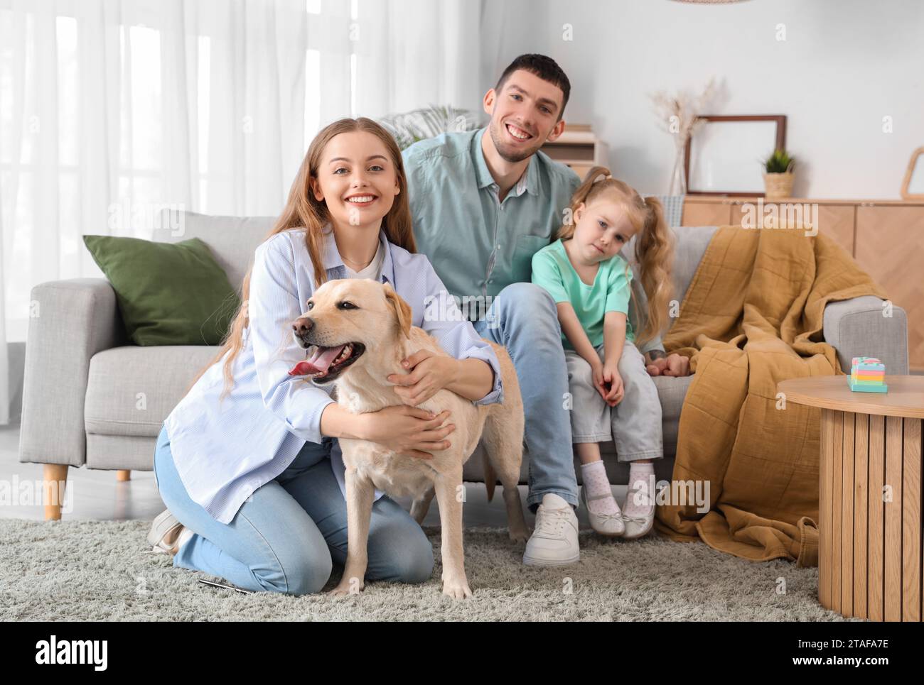Happy family with cute Labrador dog at home Stock Photo - Alamy