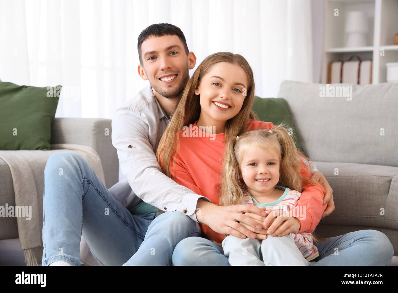 Happy parents with their little daughter hugging at home Stock Photo ...