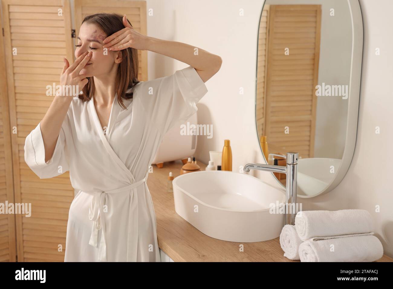 Young woman doing face building exercise in bathroom Stock Photo - Alamy