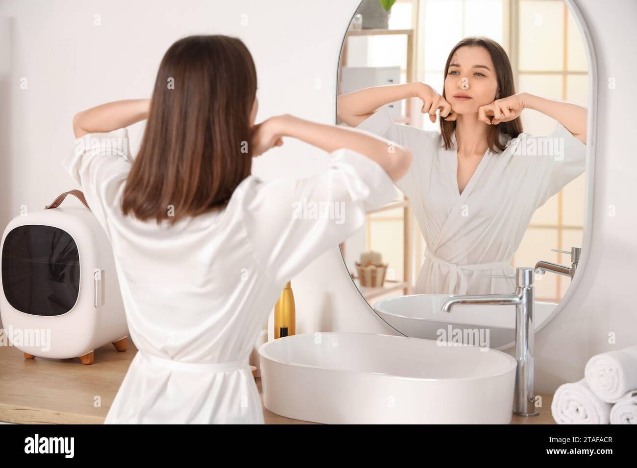 Young woman doing face building exercise near mirror in bathroom Stock ...