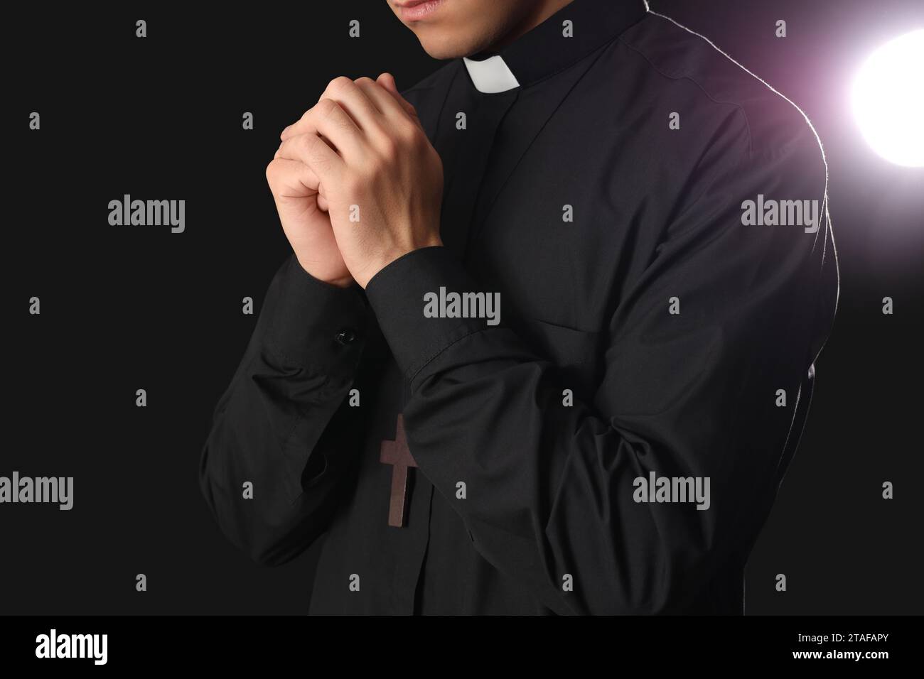Young priest praying on dark background, closeup Stock Photo - Alamy