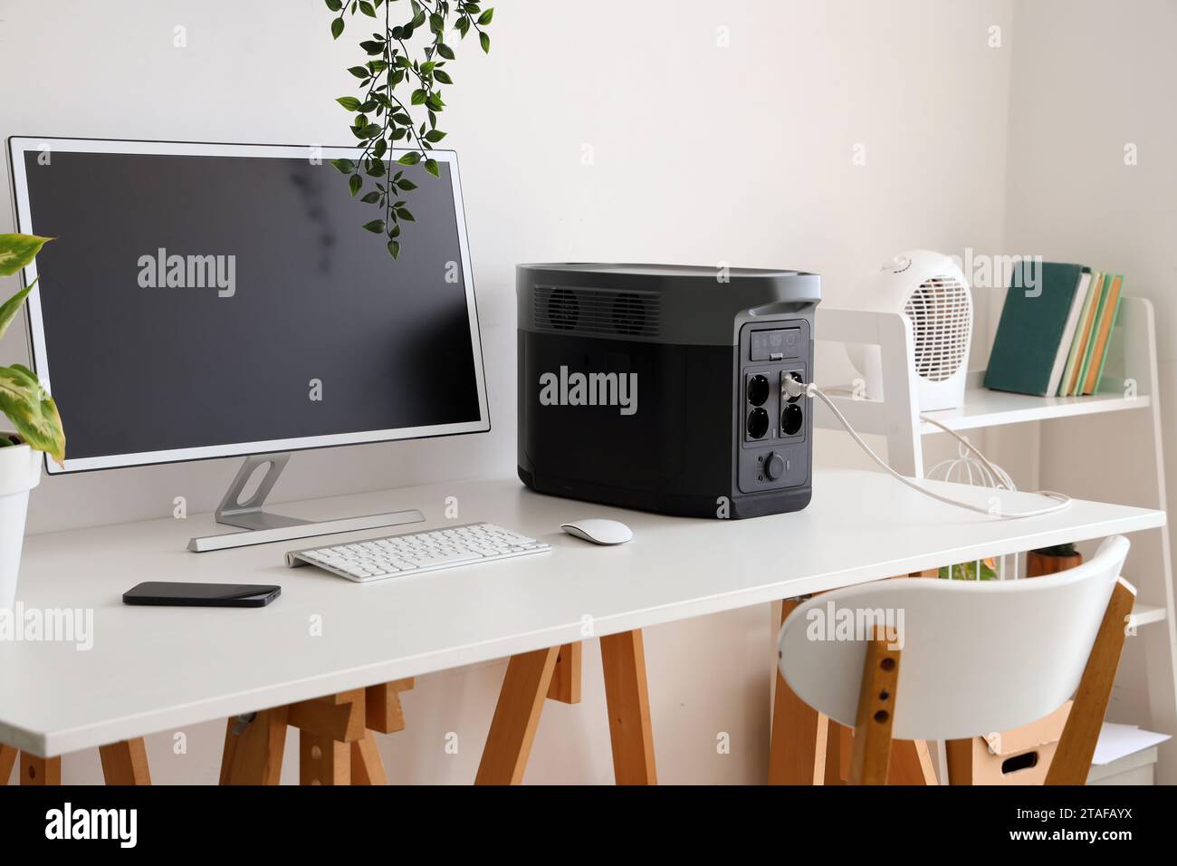 Comfortable workspace with modern computer and portable power station ...