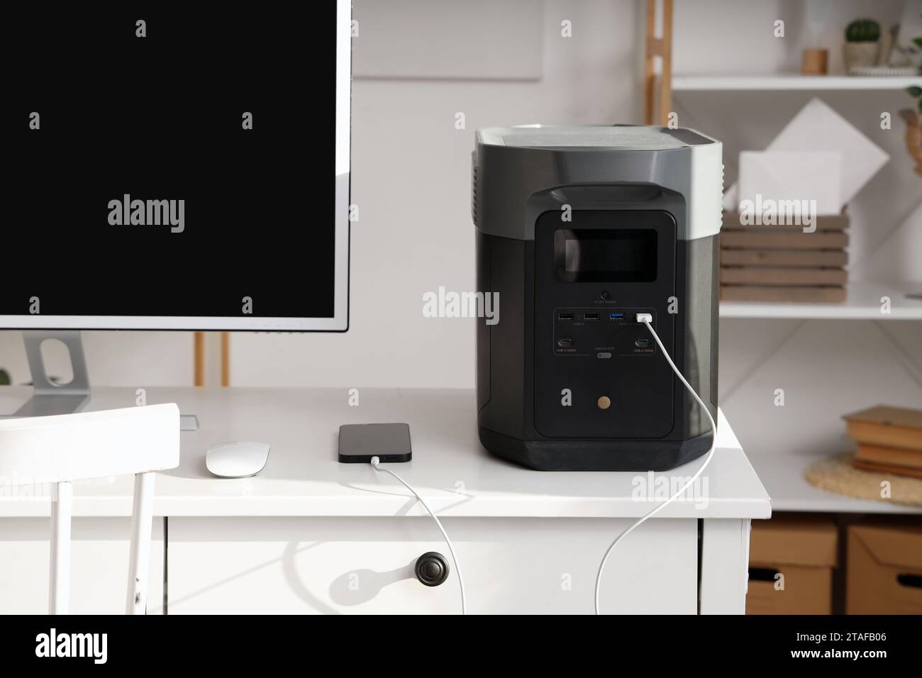 Comfortable workspace with modern computer and portable power station ...