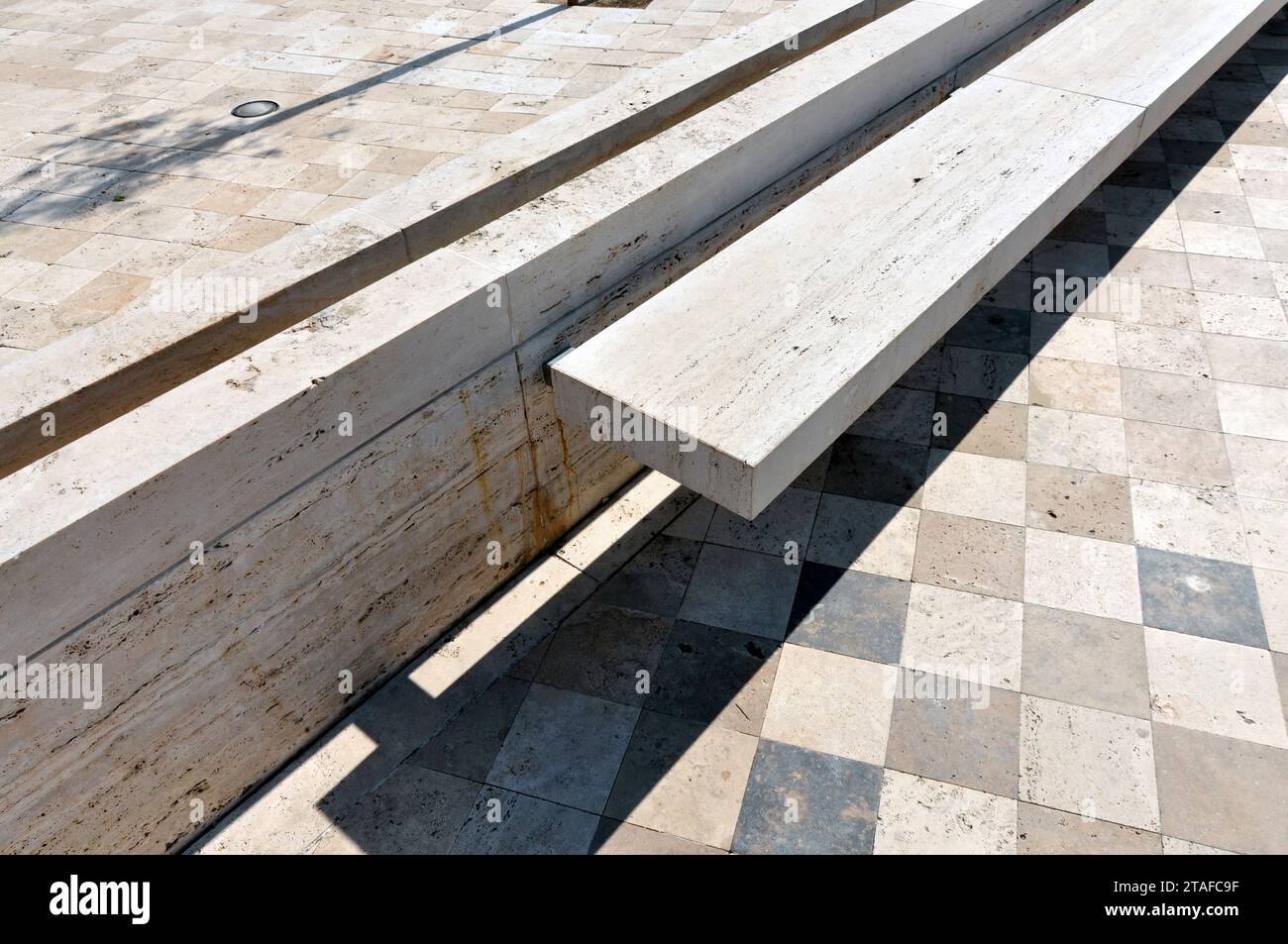 Checkerboard patterned travertine floor with cut stone bench Stock ...
