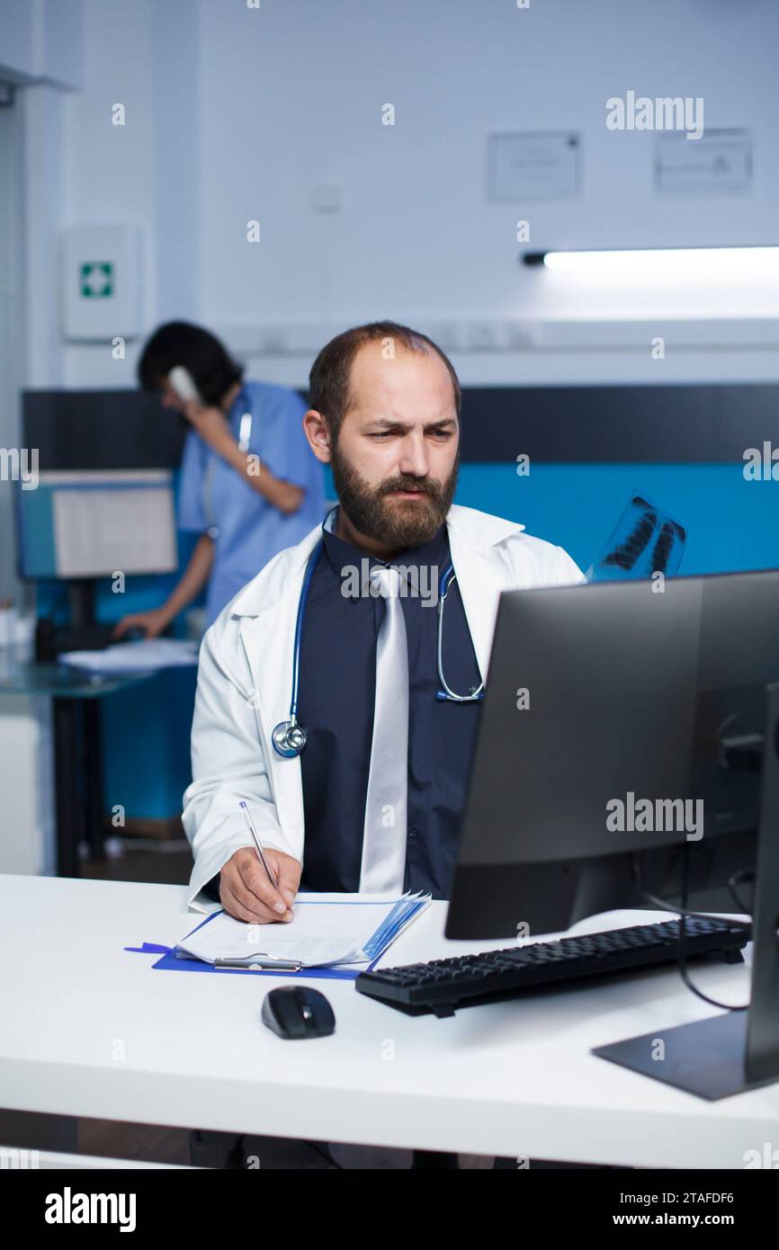 Selective focus on a white doctor studying a patient X-ray chest ...