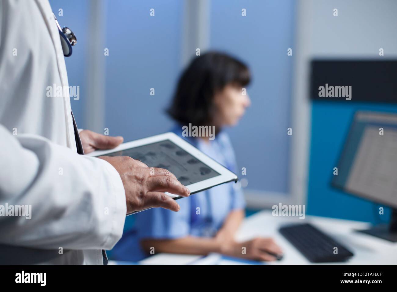 Doctor and nurse collaborate in clinic office discussing medical ...