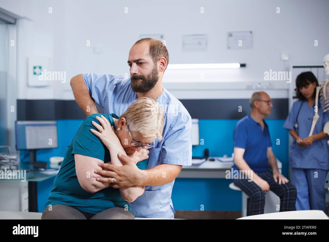 Elderly Caucasian woman gets examined by a physiotherapist. The patient ...