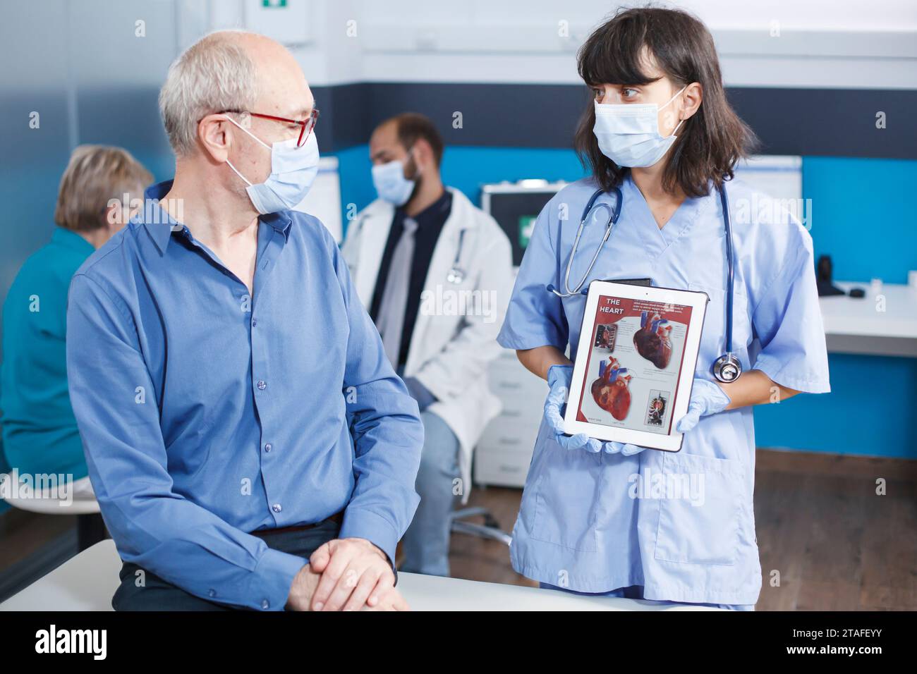 Female nurse in blue scrubs explains cardiology treatment displayed on ...