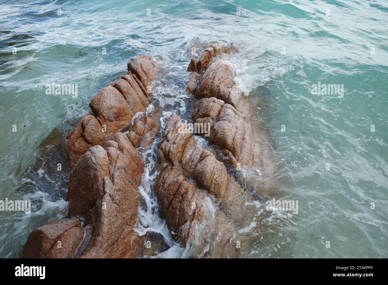 Aerial top view over sea waves with clear water crushing over the rocks ...