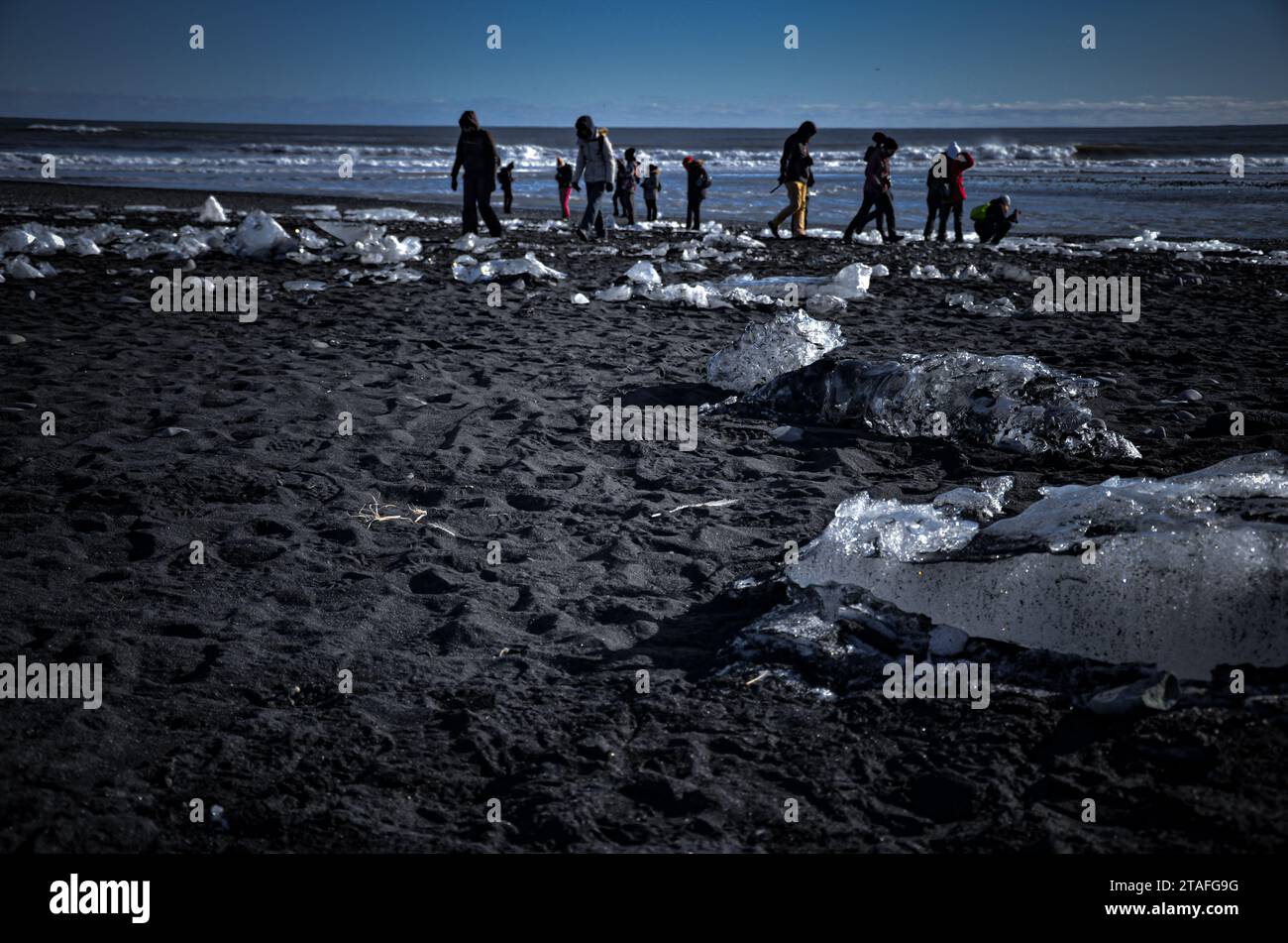 Black diamond beach in Iceland with tourists Stock Photo - Alamy