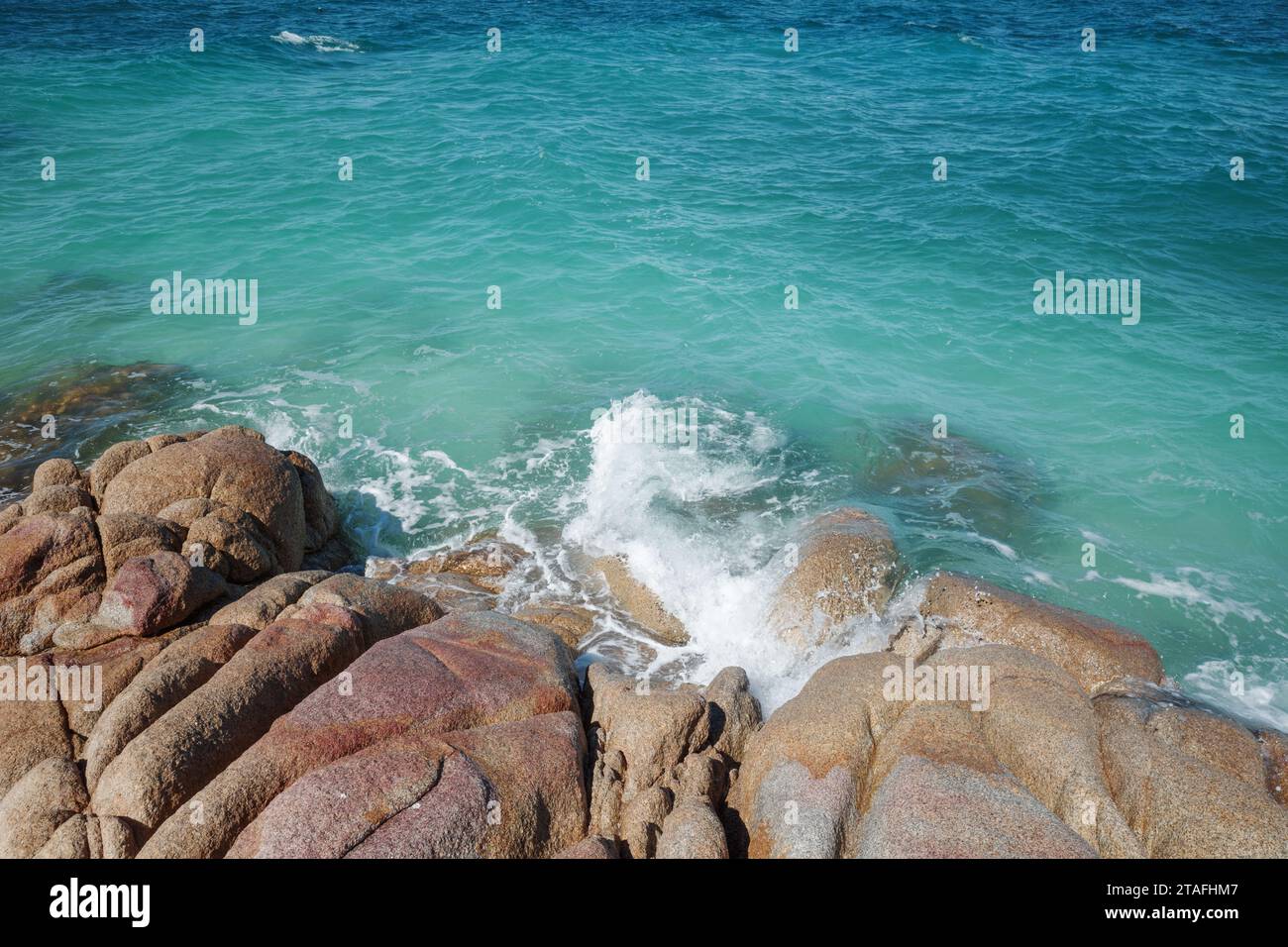Aerial top view over sea waves with clear water crushing over the rocks ...
