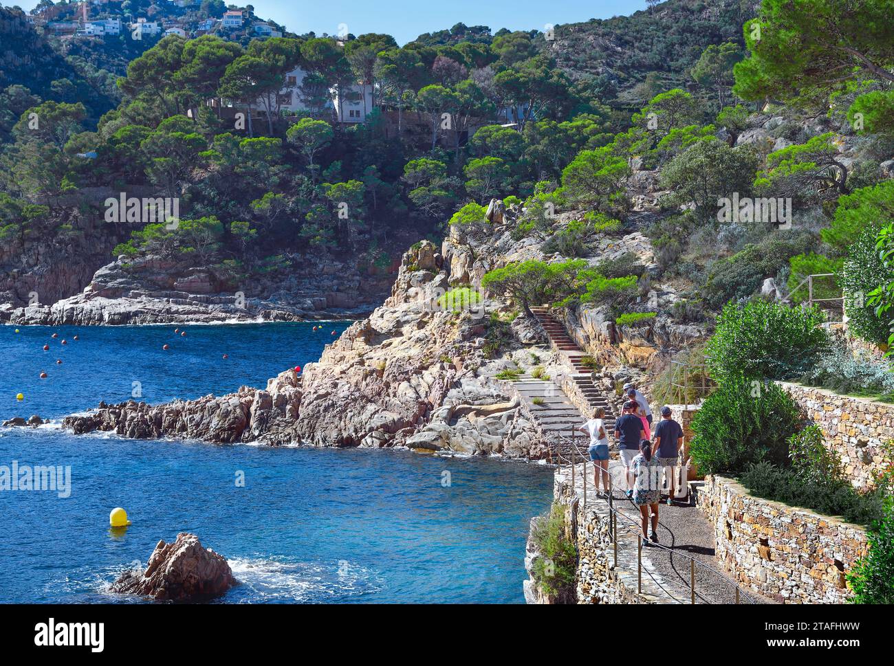 Holidaymakers walking along Camino de Ronda, a coastal footpath through ...