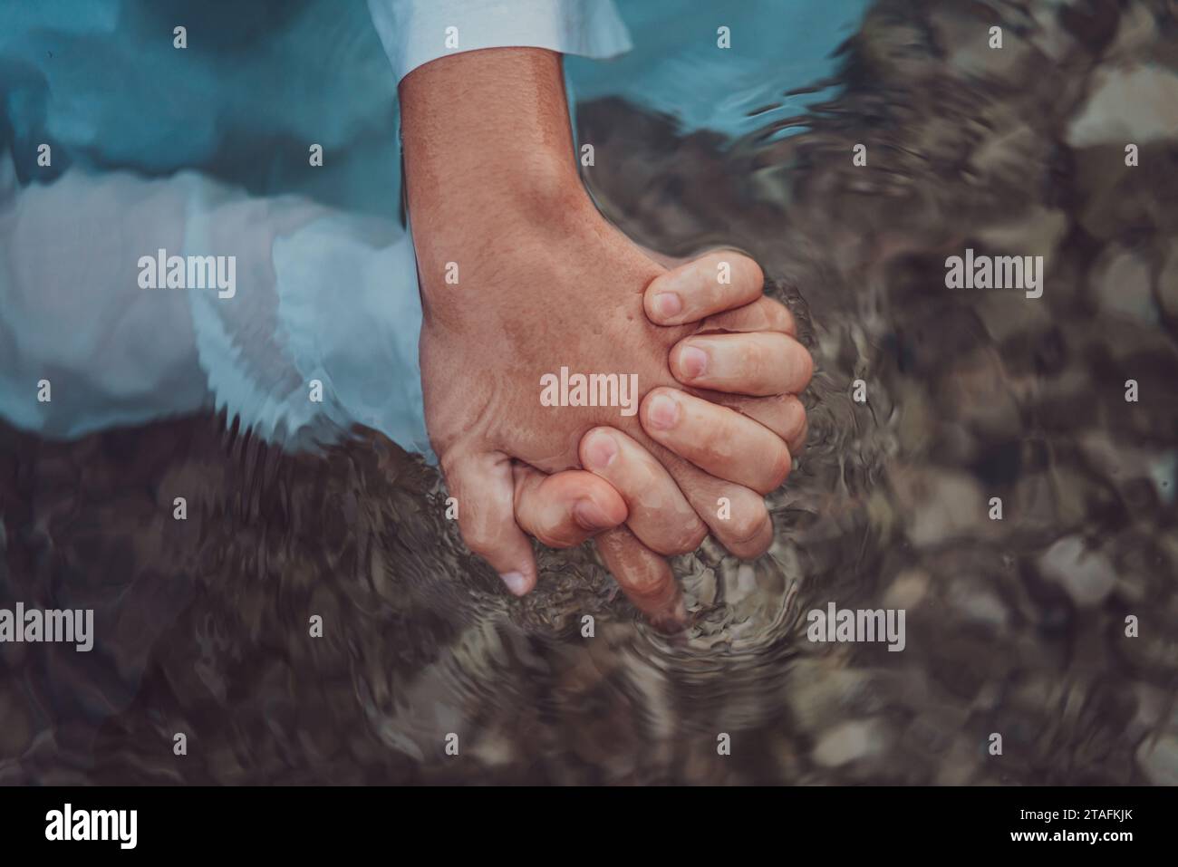Close up photo the hands of a romantic couple are intimately entwined ...