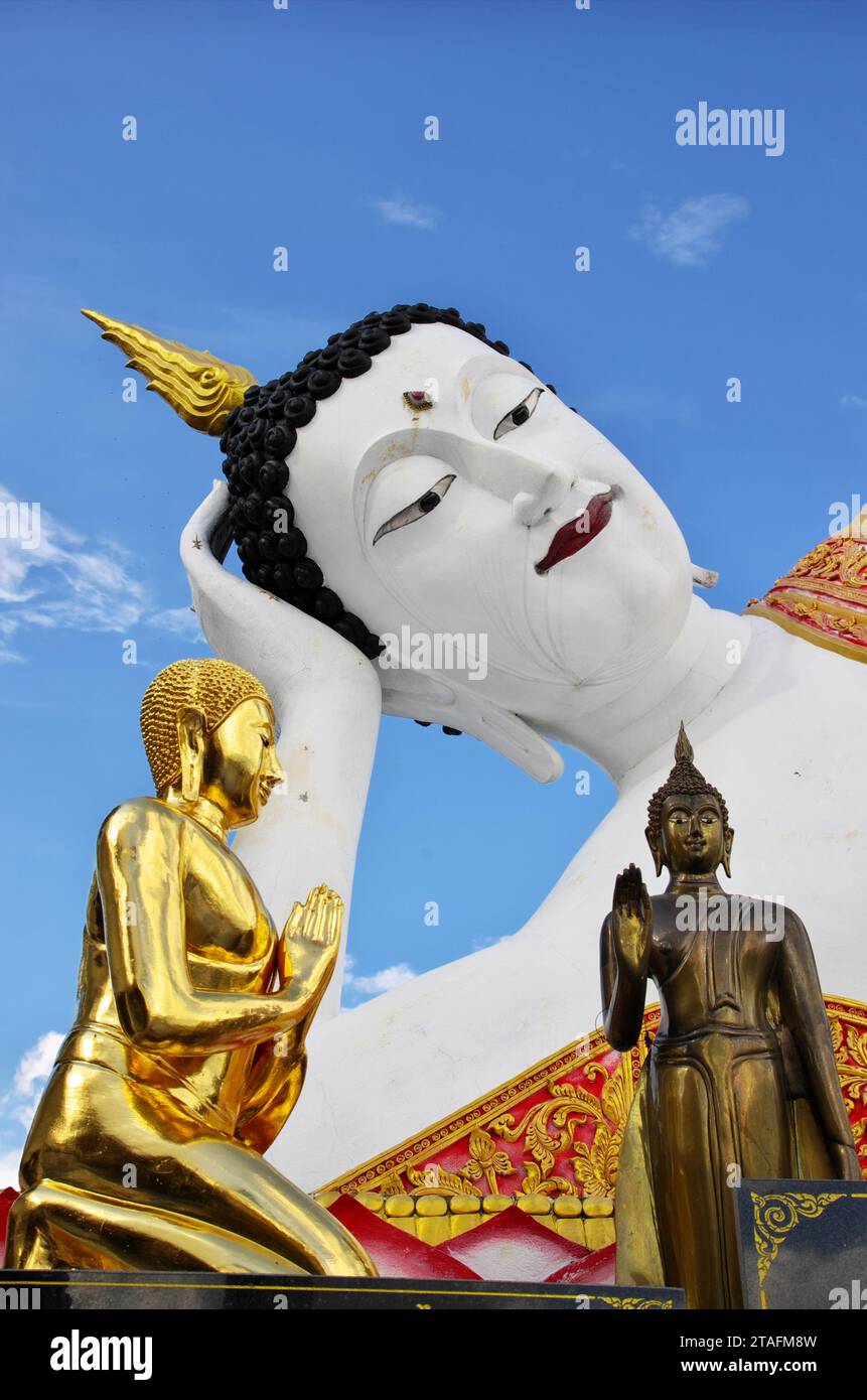 Three statues of different sizes and colors bearing the image of Buddha ...
