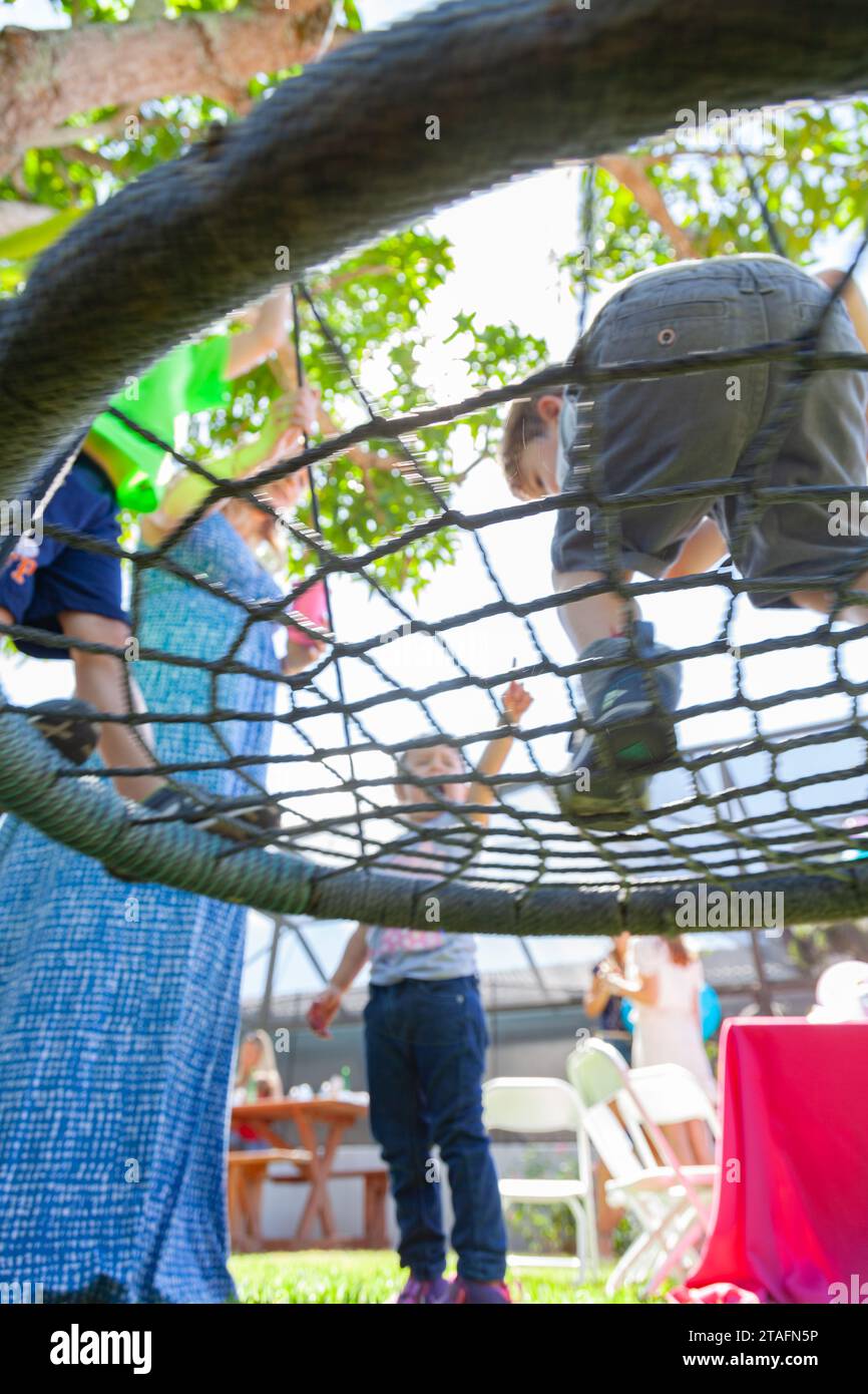 Kids ride together on a round rope swing in the backyard, Miami ...