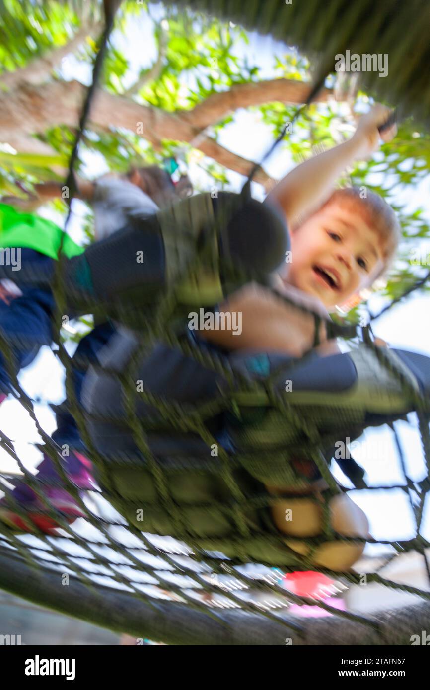 Kids ride together on a round rope swing in the backyard, Miami ...