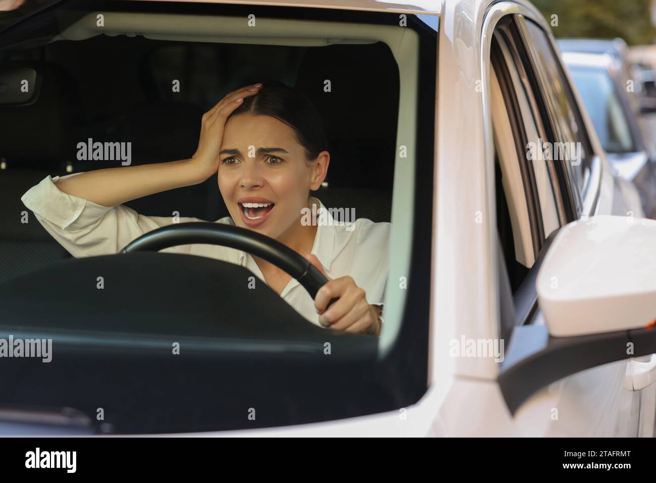 Stuck in traffic jam. Angry driver in her car, view through windshield ...