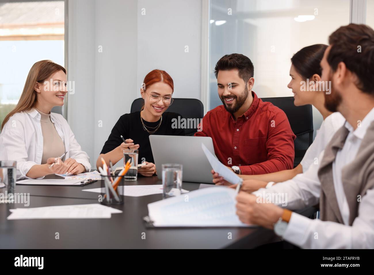 Team of employees working together in office Stock Photo - Alamy