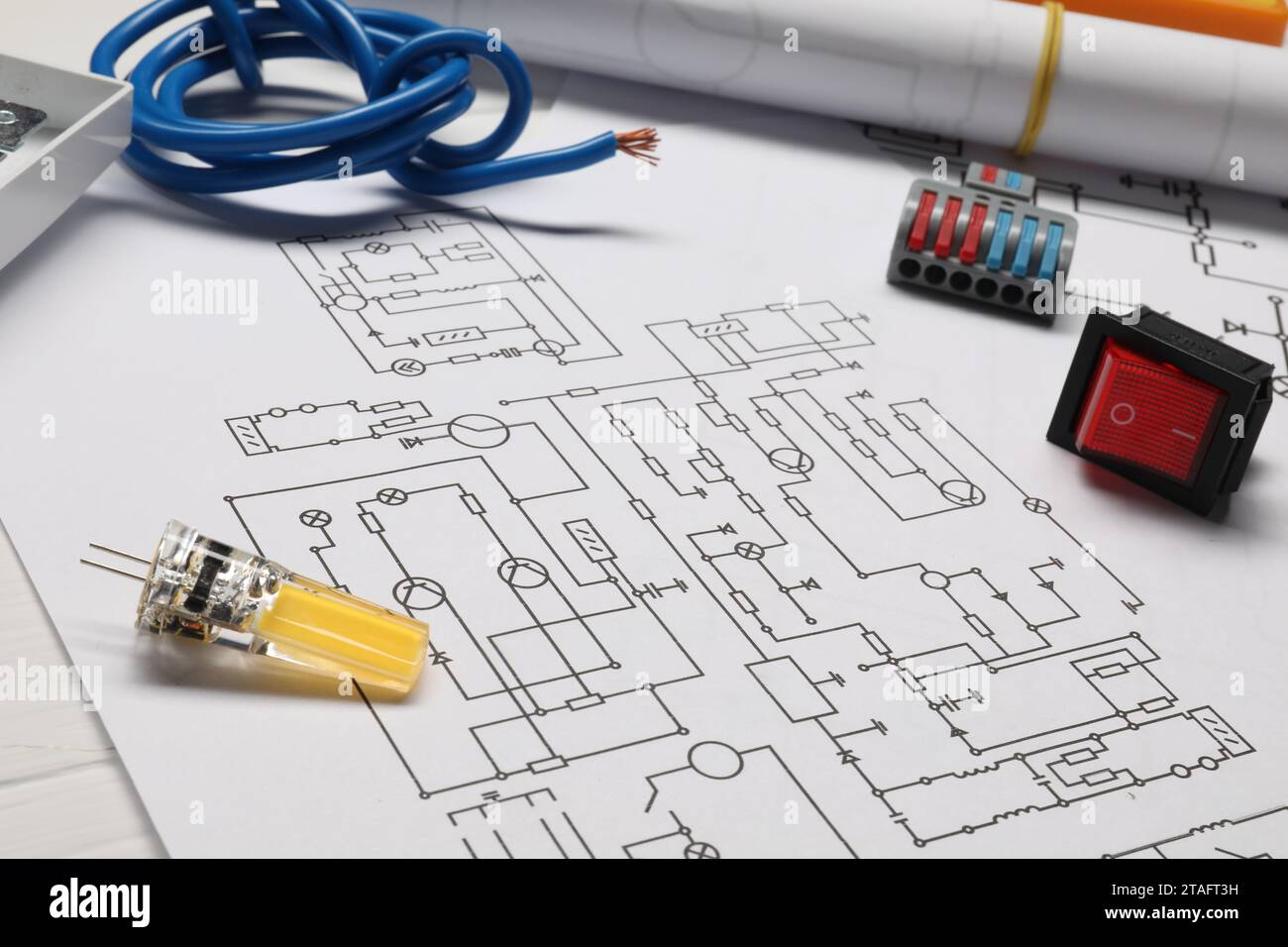 Wiring diagram, wires and other electrician's equipment on white table ...