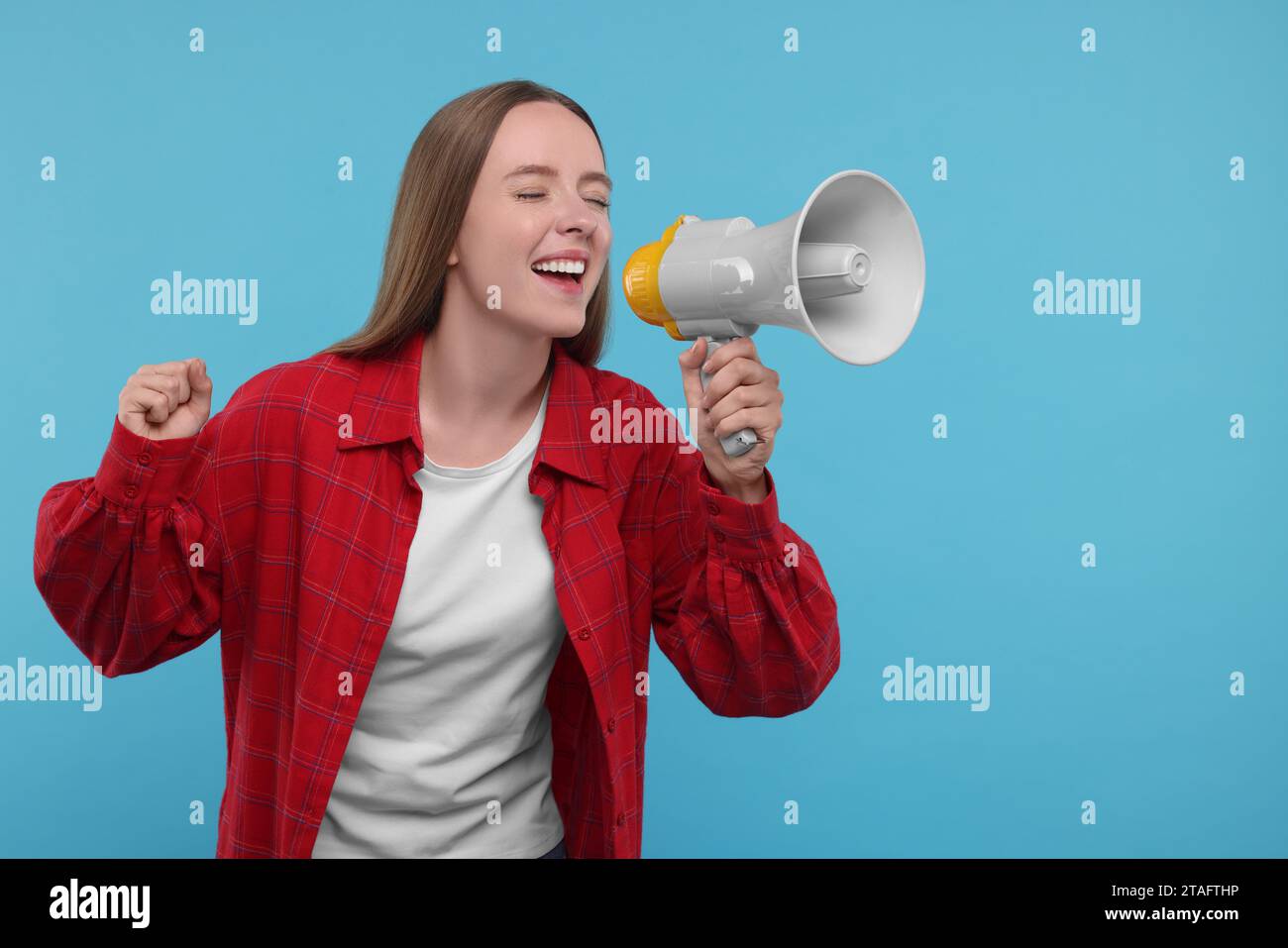 Emotional sports fan with megaphone on light blue background. Space for ...