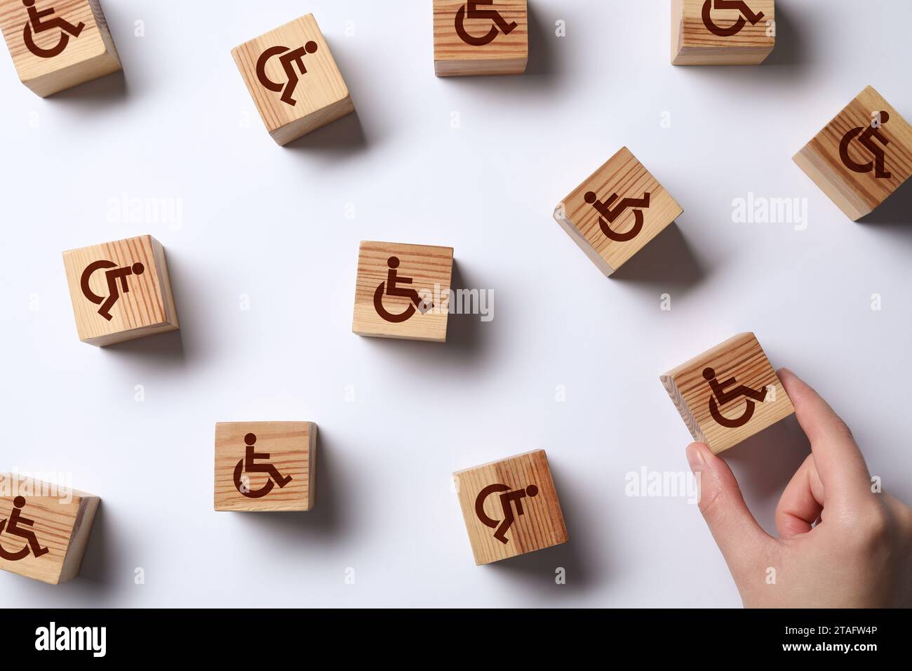 Inclusion concept. Woman arranging wooden cubes with international ...