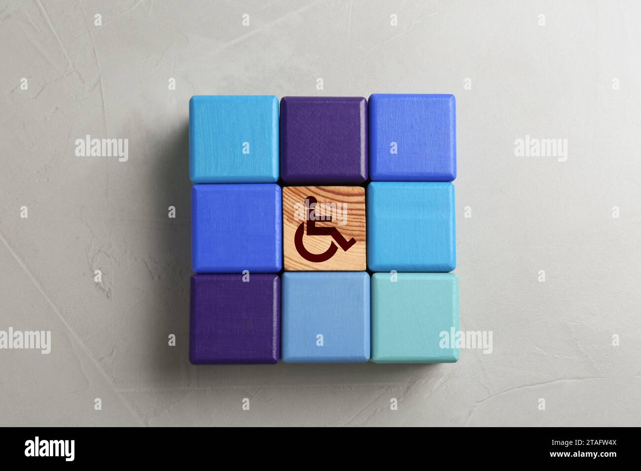 Inclusion concept. Wooden cube with international symbol of access ...