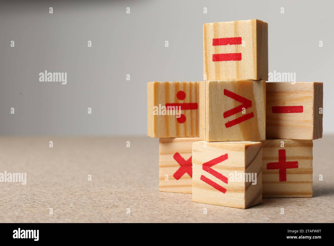 Wooden Cubes With Mathematical Symbols On Table Against Light