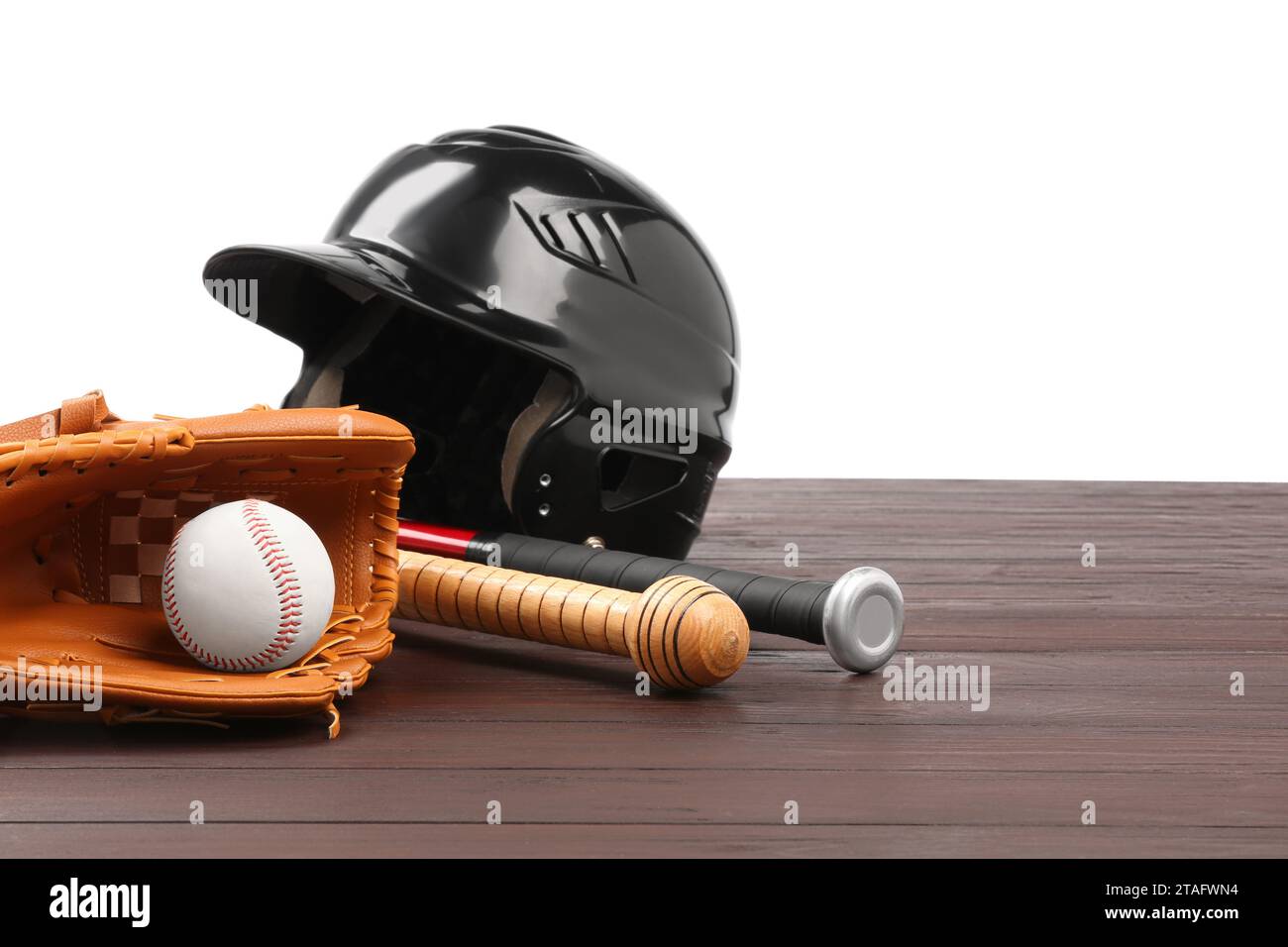 Baseball glove, bats, ball and batting helmet on wooden table against ...