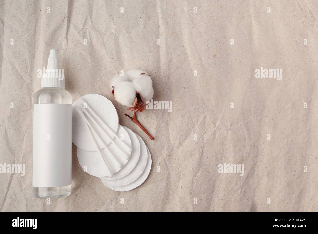 Flat lay composition with makeup remover and cotton flower on crumpled ...