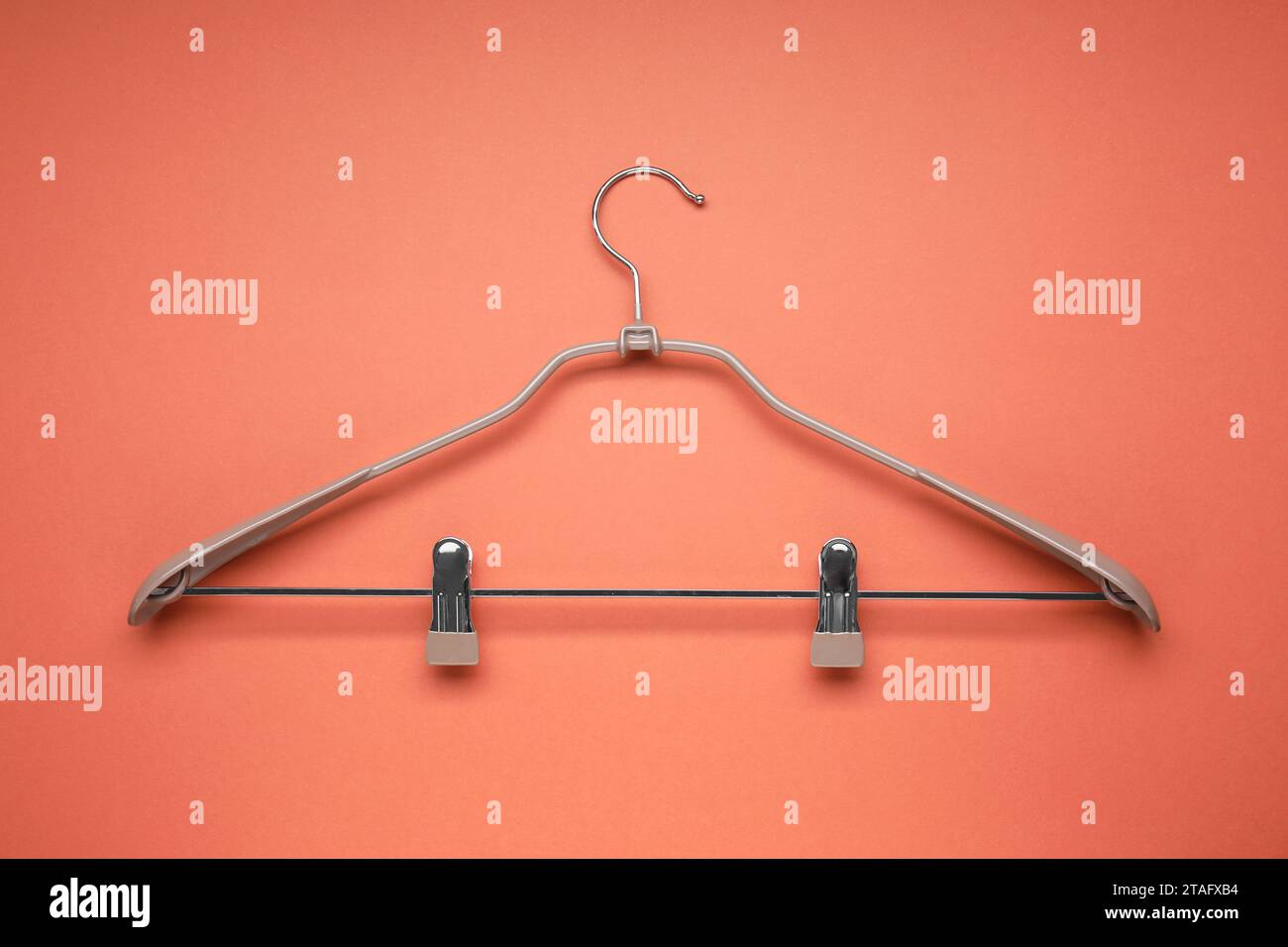 Empty hanger with clips on coral background, top view Stock Photo - Alamy
