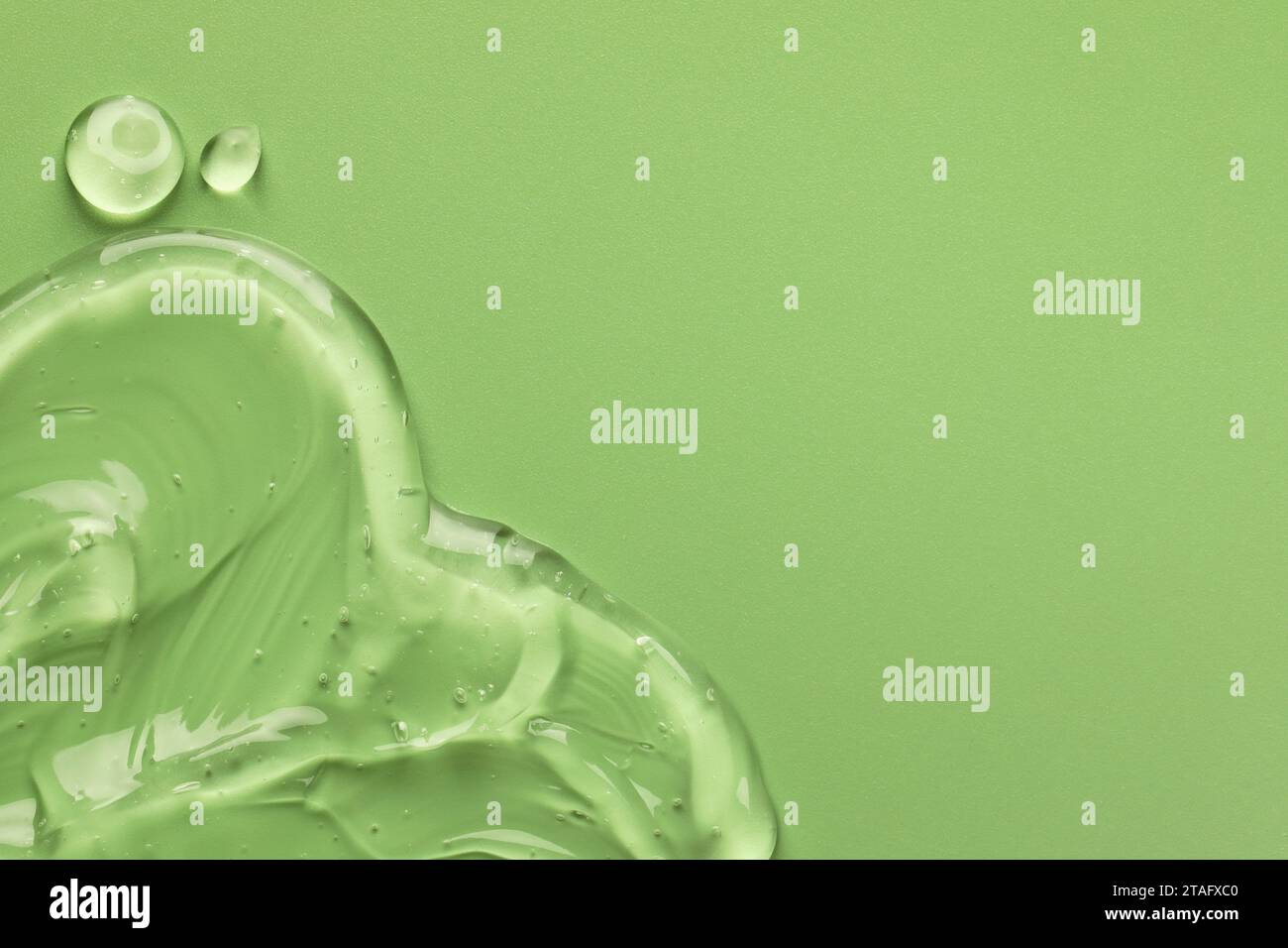 Clear cosmetic gel on light green background, top view. Space for text ...