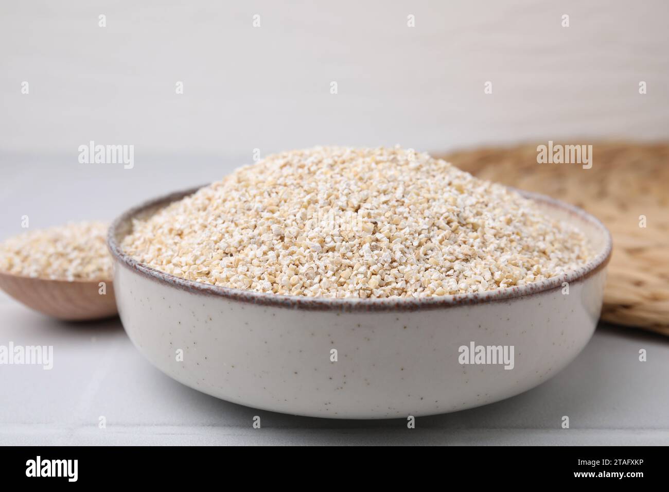 Raw barley groats in bowl on light table, closeup Stock Photo - Alamy