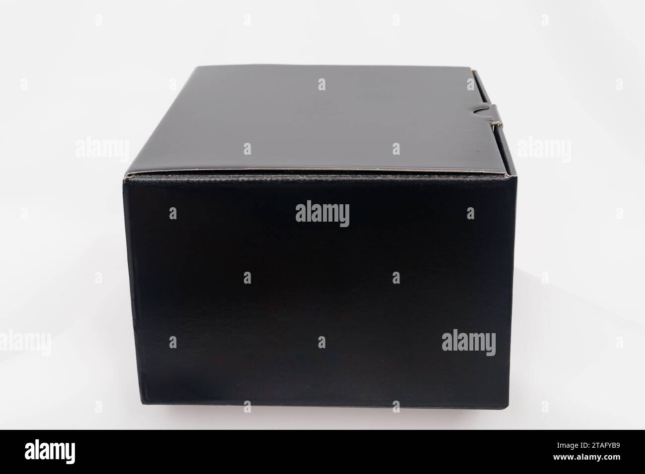 Black cardboard box on white background. Side view Stock Photo - Alamy