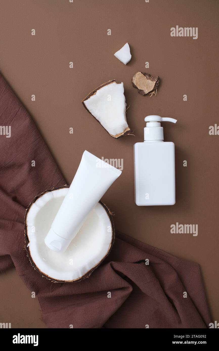 Flat lay of dark towel on brown backdrop, fresh coconut and an ...