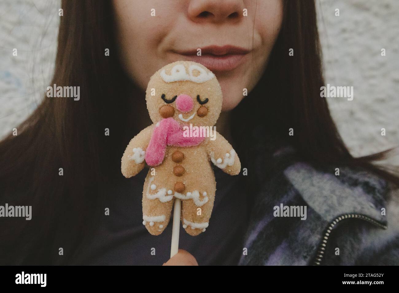 Christmas cookie in female hand. A girl is eating gingerbread man ...