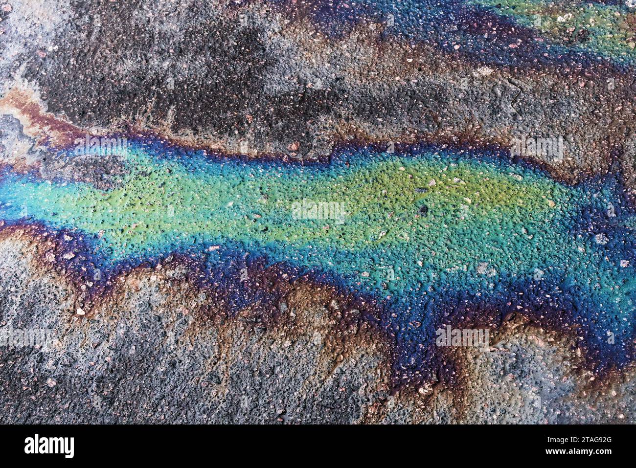 Colored texture of oil products on the asphalt in the rain. Oil dripped ...