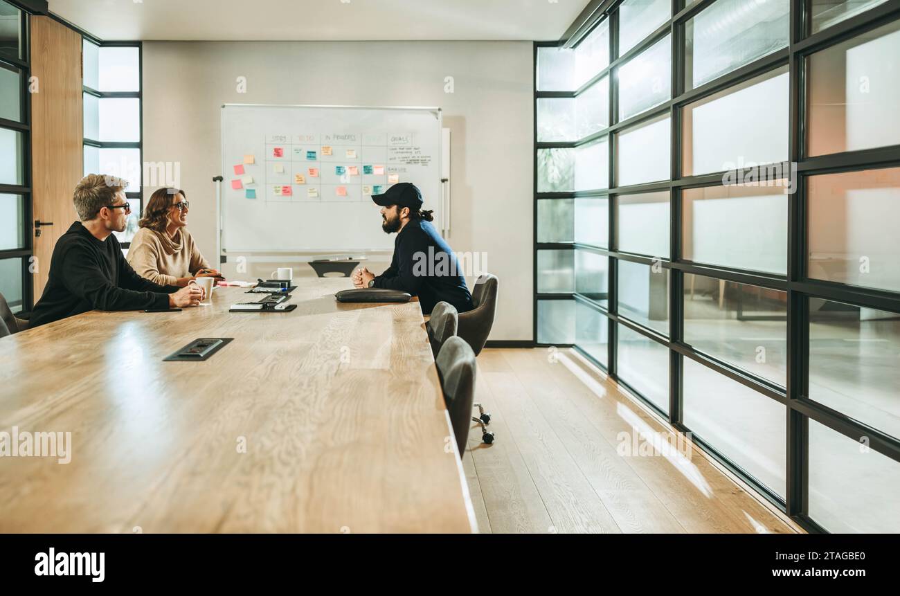 Professionals engage in a dynamic discussion in a modern boardroom ...