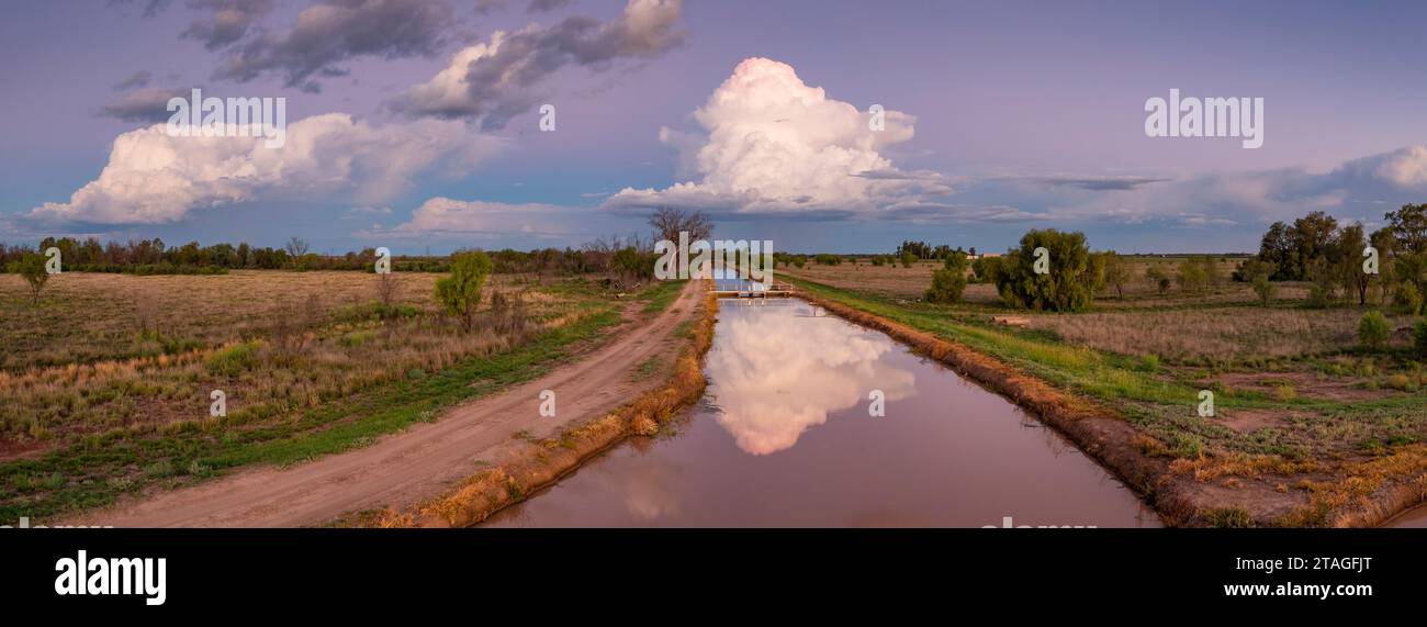 Aerial panoramic view over an irrigation channel with an evening ...