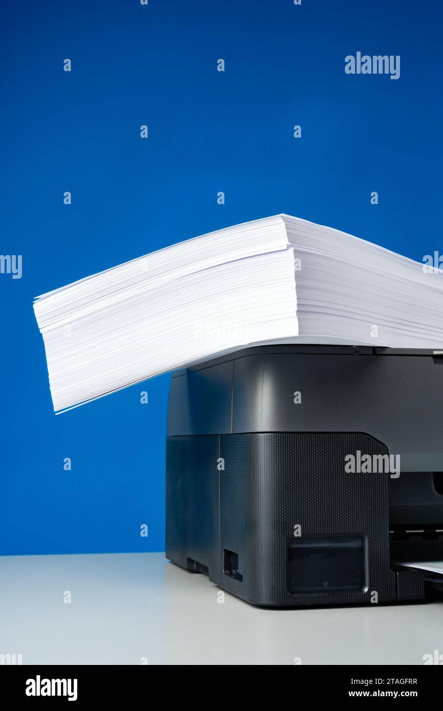Laser printer on desk against blue background Stock Photo - Alamy