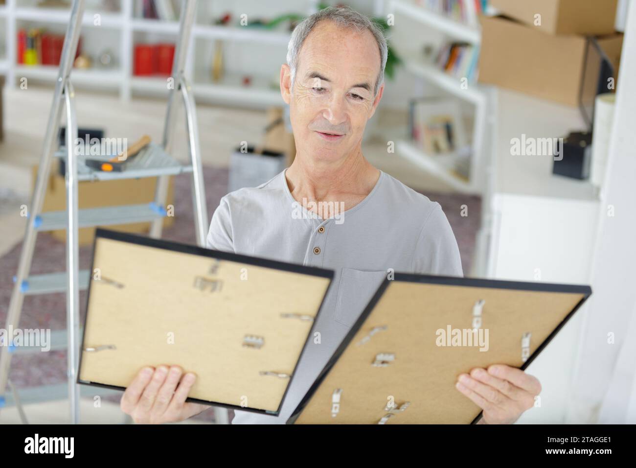 positive man is choosing new picture for his home Stock Photo - Alamy