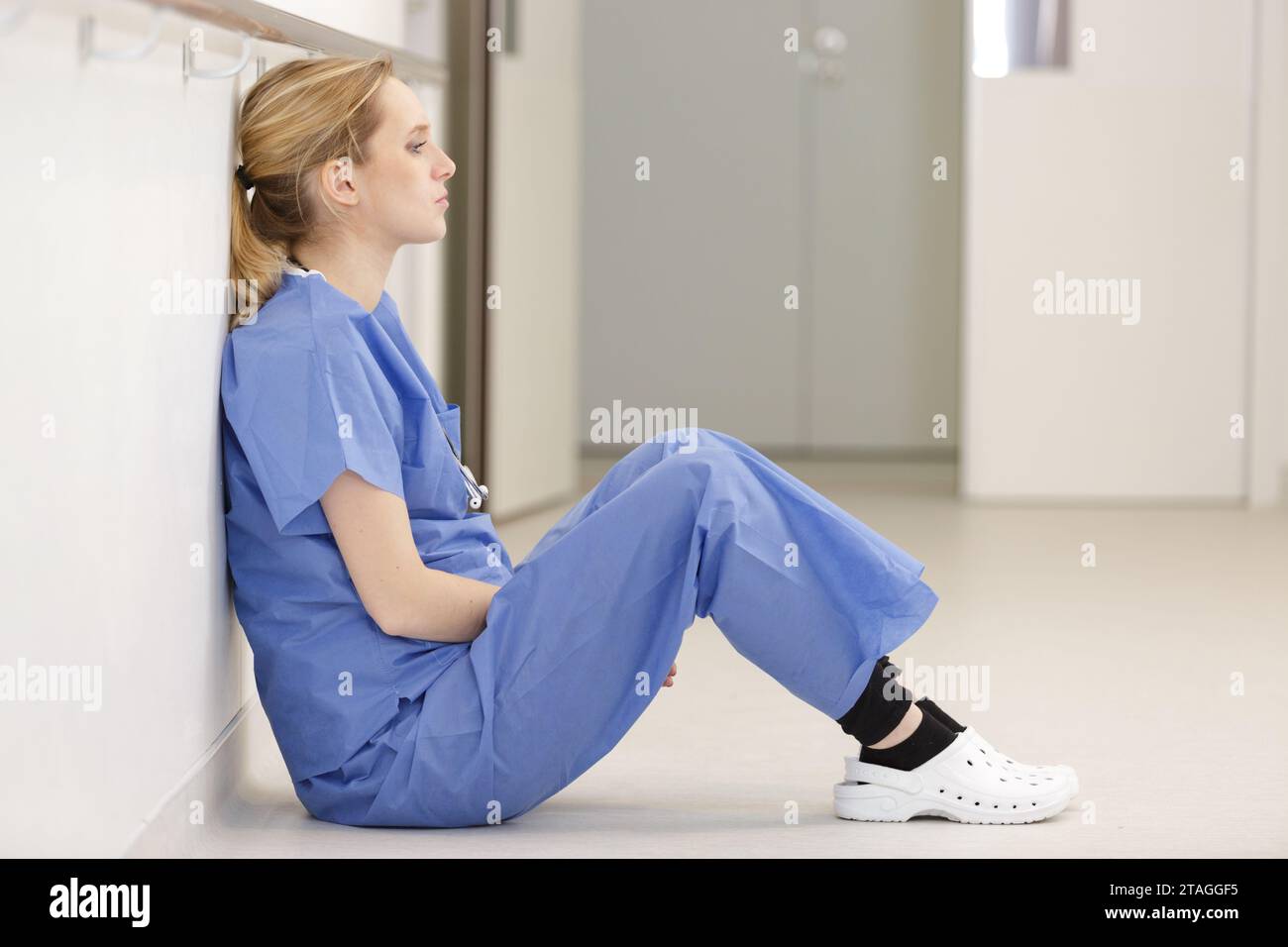 nurse sitting alone on the floor in a hospital corridor Stock Photo - Alamy
