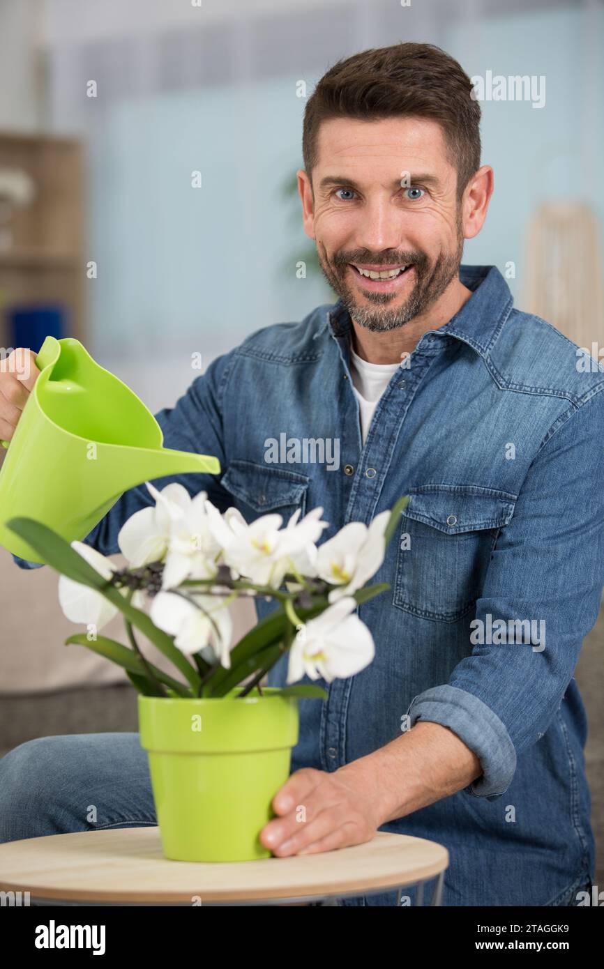 happy man keeping plants refreshed Stock Photo - Alamy