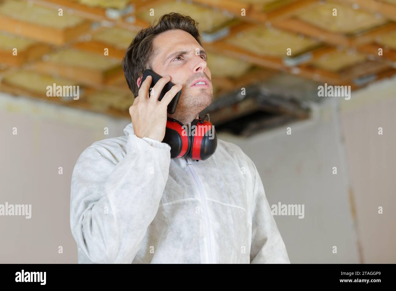 builder on the phone by a ladder Stock Photo - Alamy